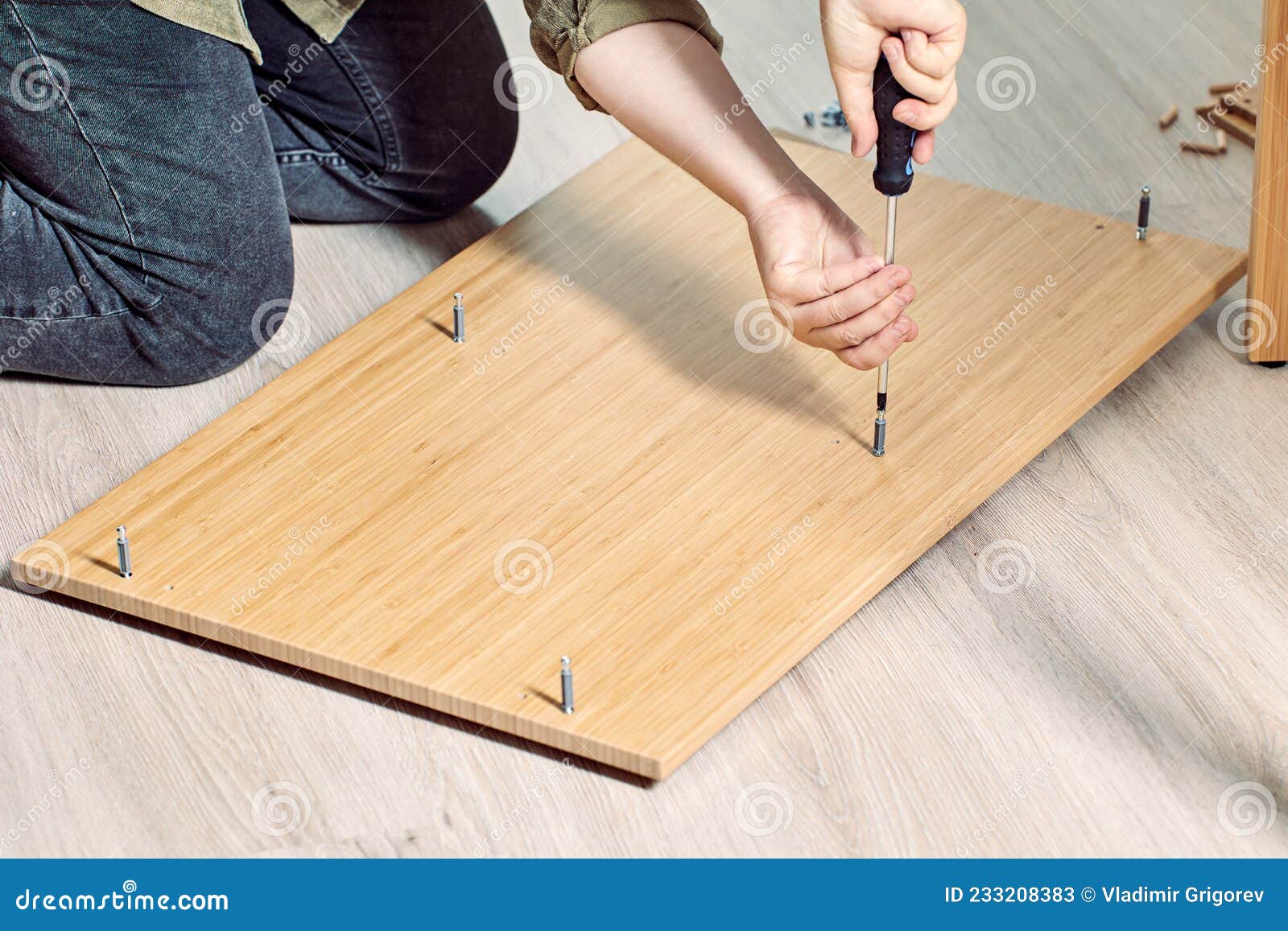 Handyman Is Assembling Flat Pack Furniture With Help Of Screwdriver