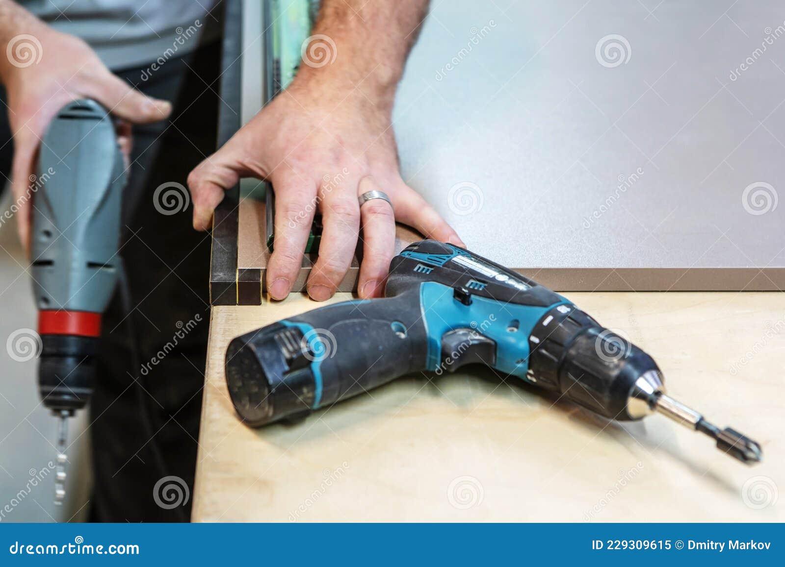 Assembling Furniture with a Power Tool. a Carpenter Works in a Workshop ...