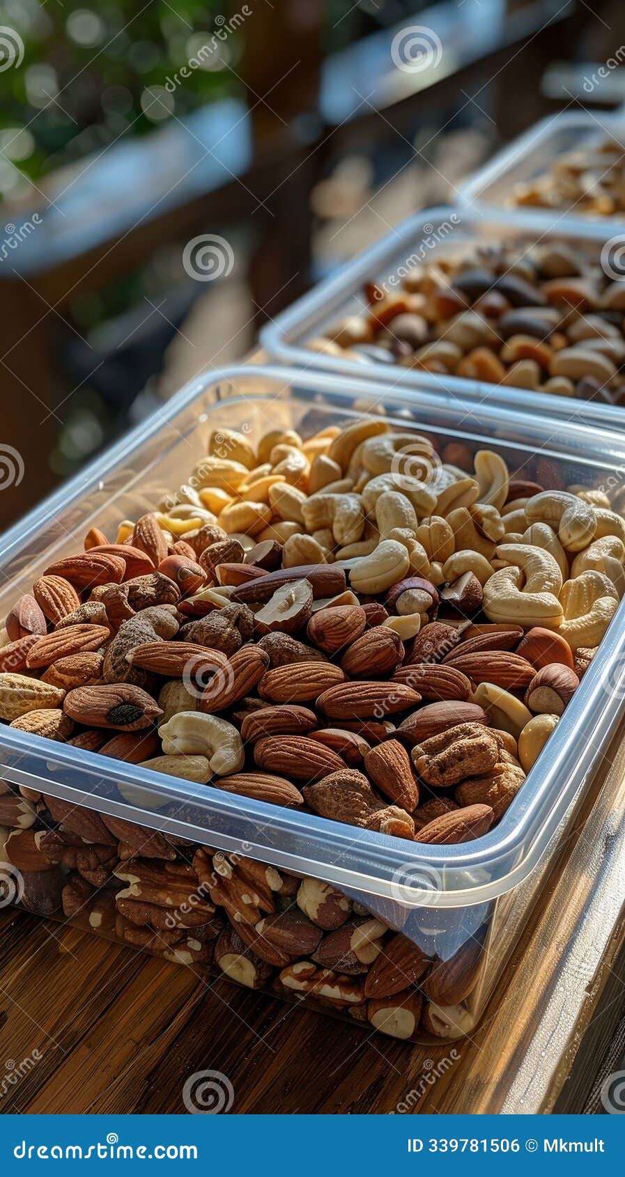 Assorted Nuts and Peanuts in a Plastic Container on a Wooden Table for ...
