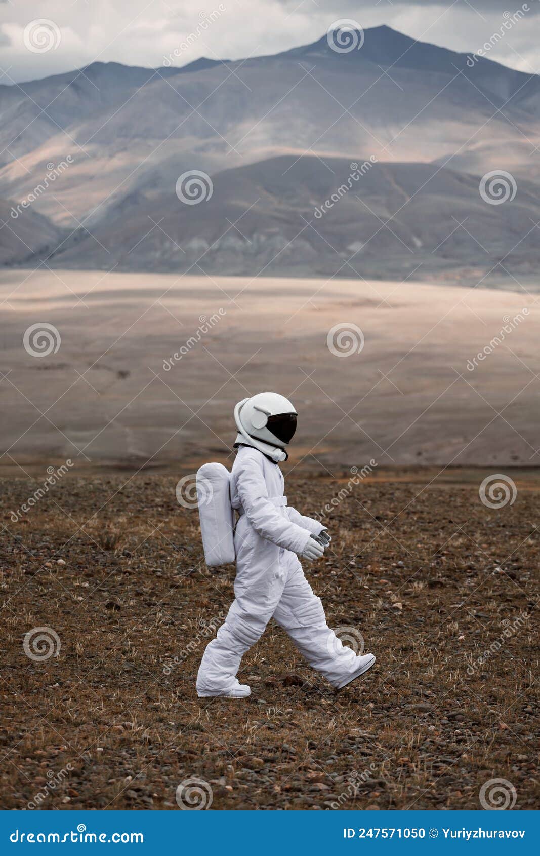 Astronaut Explores an Unknown Red Planet. Cloudy Sky and Mountains in ...