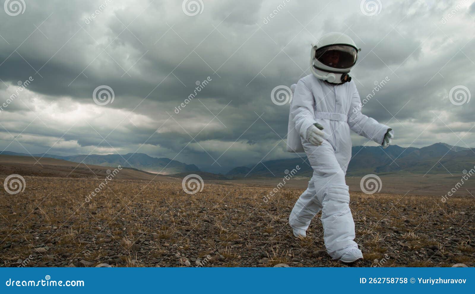 Astronaut Explores an Unknown Red Planet. Cloudy Sky and Mountains in ...