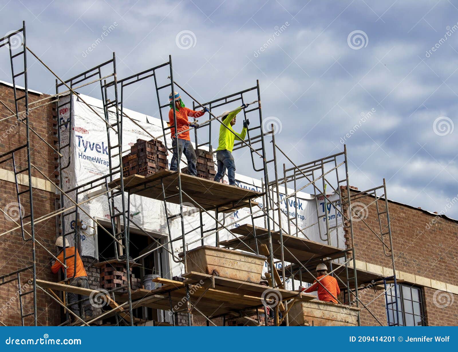 Masons On Scaffolding Install Brick Veneer On A New Building Editorial
