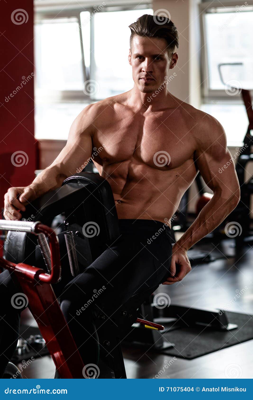 Athlete Bodybuilder Training on Simulator in the Gym Stock Photo ...