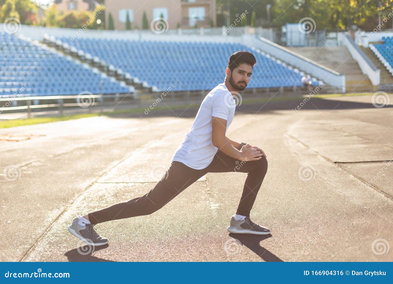 Young Indian Man Doing Stretching Exercise on Running Track Stock Photo ...