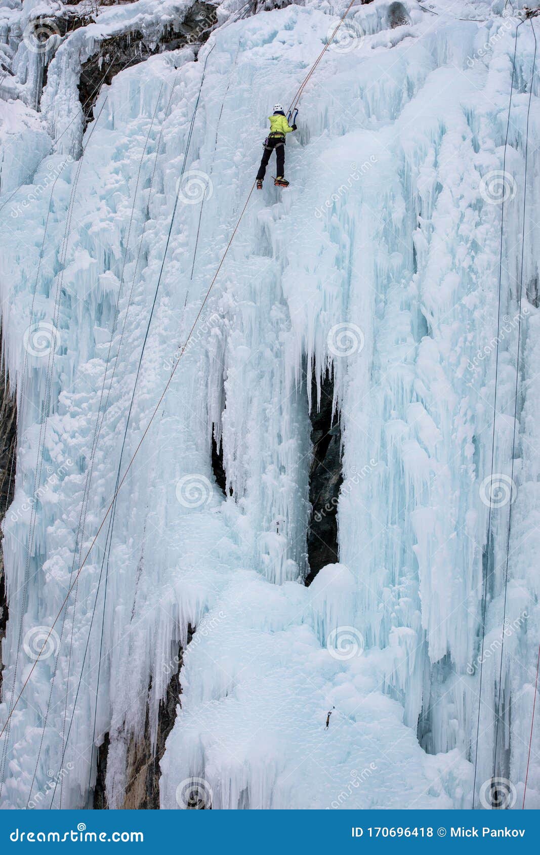 The Athlete is Engaged in Winter Mountaineering. Ice Wall Climbing ...