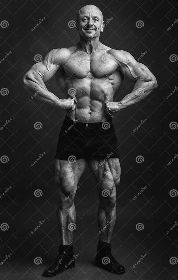 Athlete in Front Lat Spread Pose. Bodybuilder Showing Muscles on Studio ...
