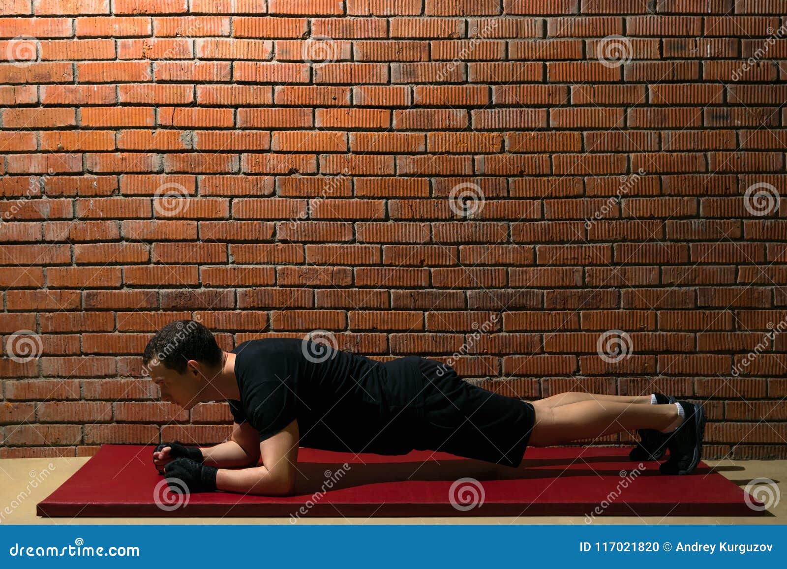 Athlete in the Hall Doing an Exercise on a Red Mat for Training a Press ...