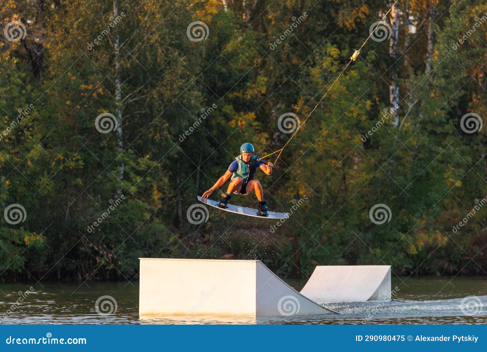 An Athlete Jumps from a Springboard. Wakeboard Park at Sunset Stock ...