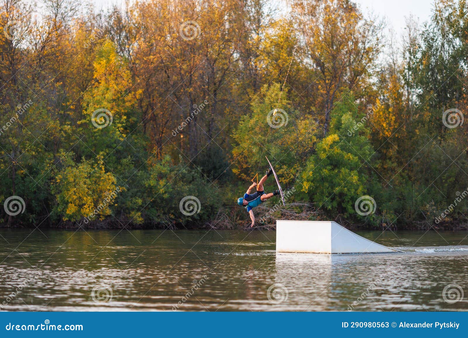 An Athlete Jumps from a Springboard. Wakeboard Park at Sunset Stock ...