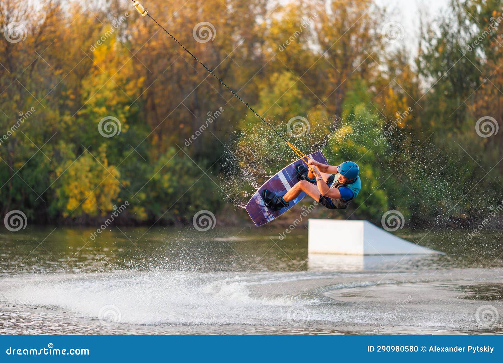 An Athlete Jumps from a Springboard. Wakeboard Park at Sunset Stock ...