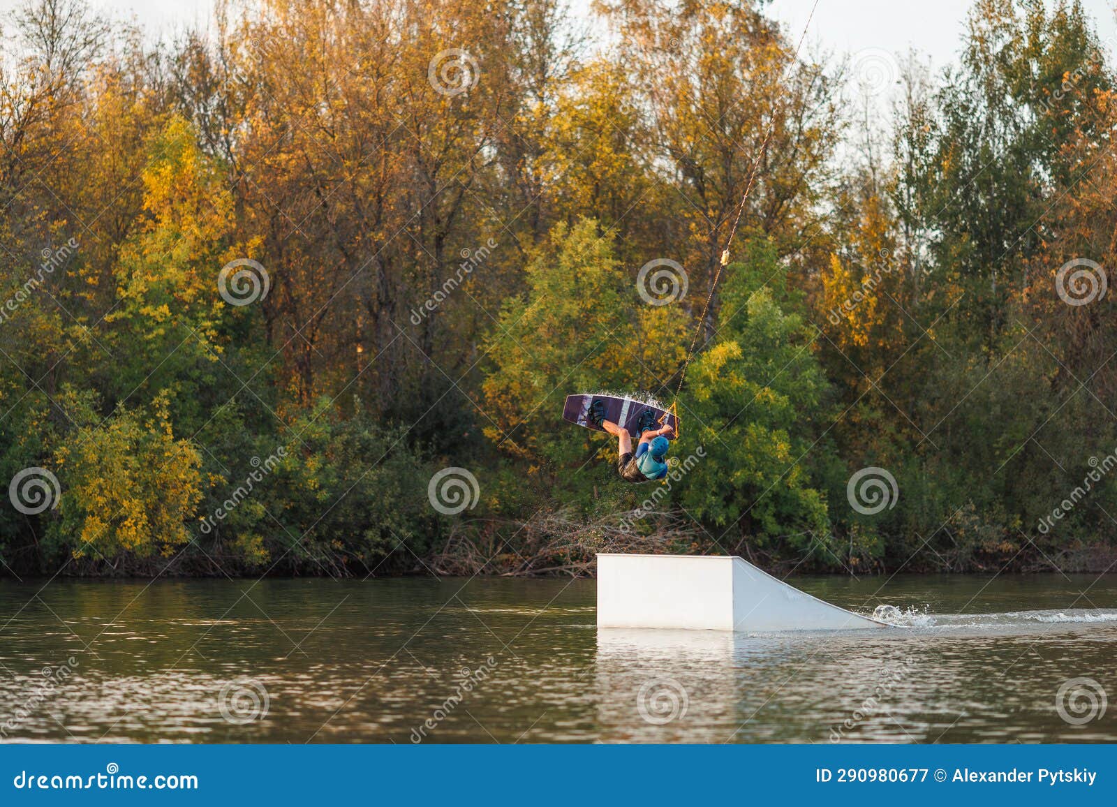 An Athlete Jumps from a Springboard. Wakeboard Park at Sunset Stock ...