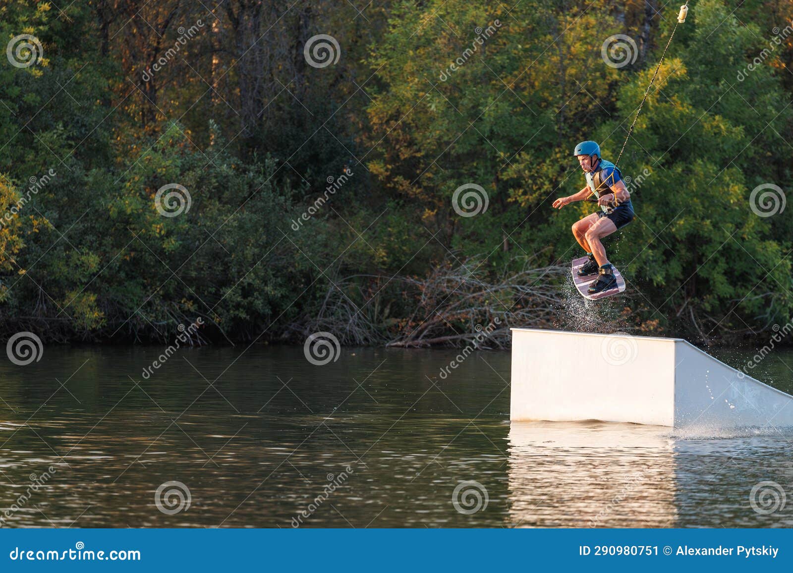 An Athlete Jumps from a Springboard. Wakeboard Park at Sunset Stock ...