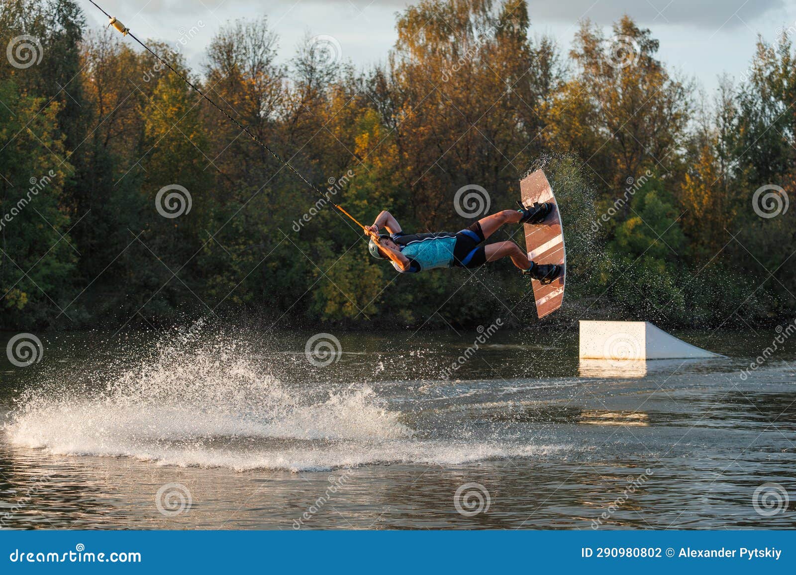 An Athlete Jumps from a Springboard. Wakeboard Park at Sunset Stock ...