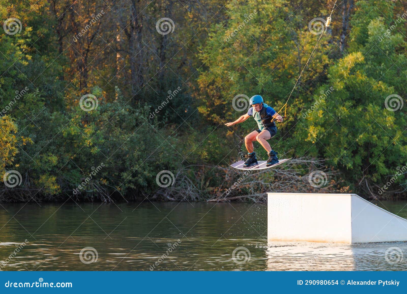 An Athlete Jumps from a Springboard. Wakeboard Park at Sunset Stock ...