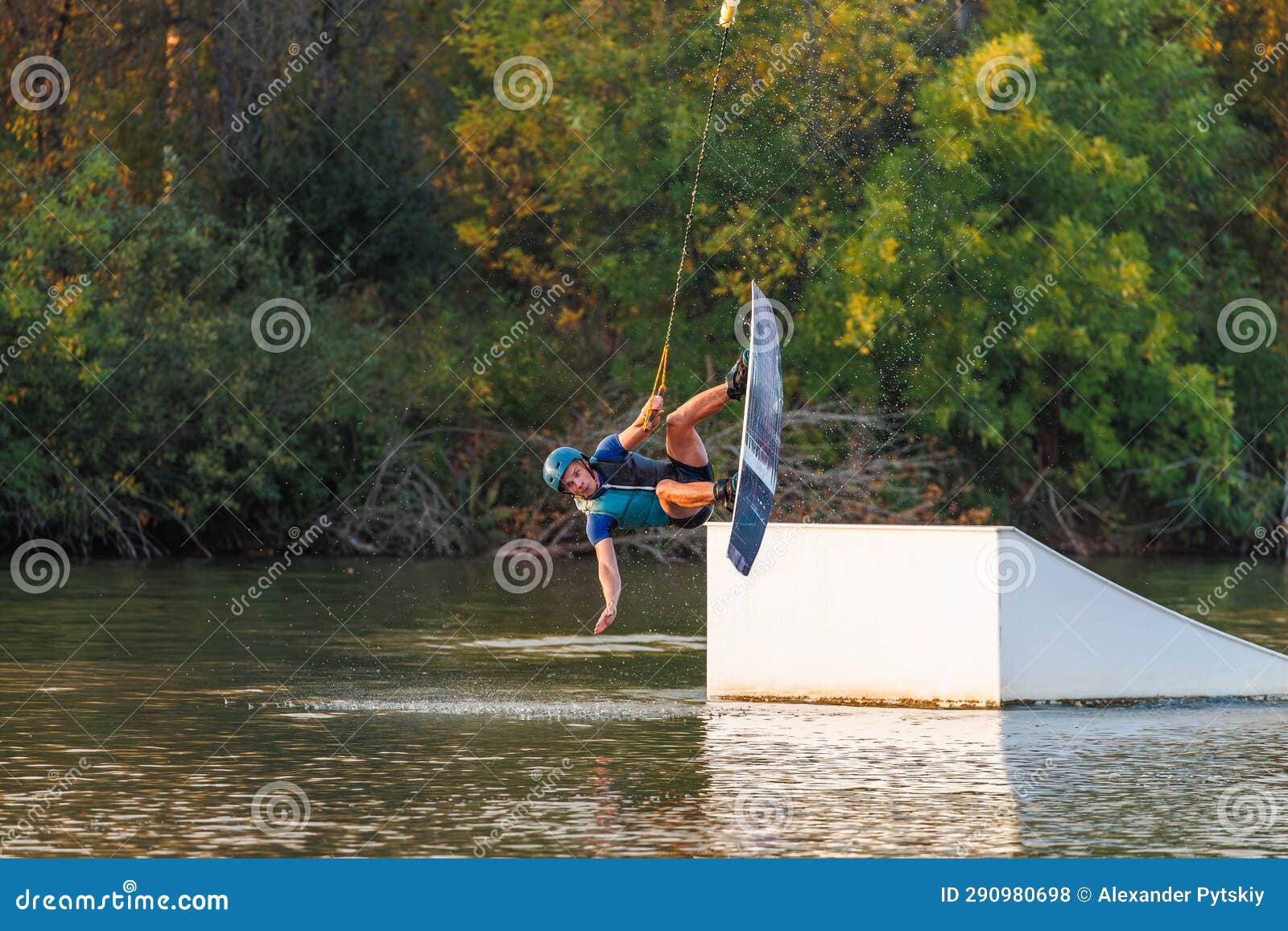An Athlete Jumps from a Springboard. Wakeboard Park at Sunset Stock ...
