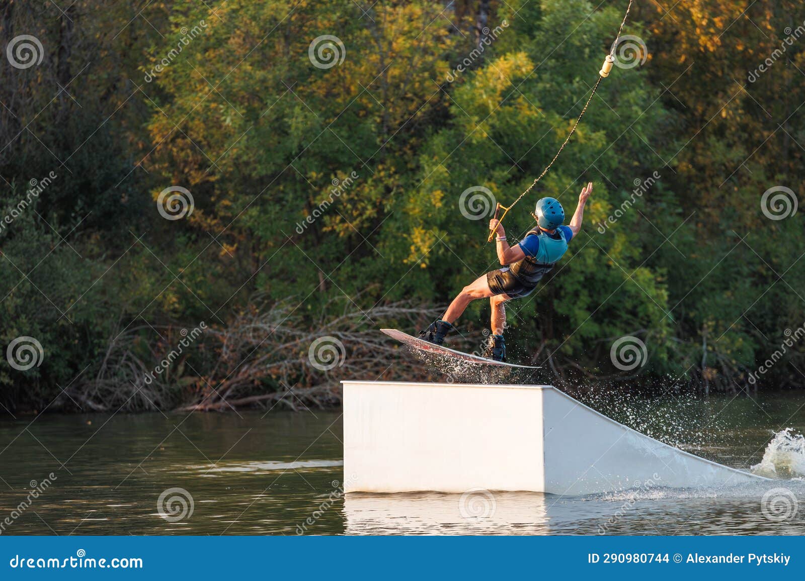 An Athlete Jumps from a Springboard. Wakeboard Park at Sunset Stock ...