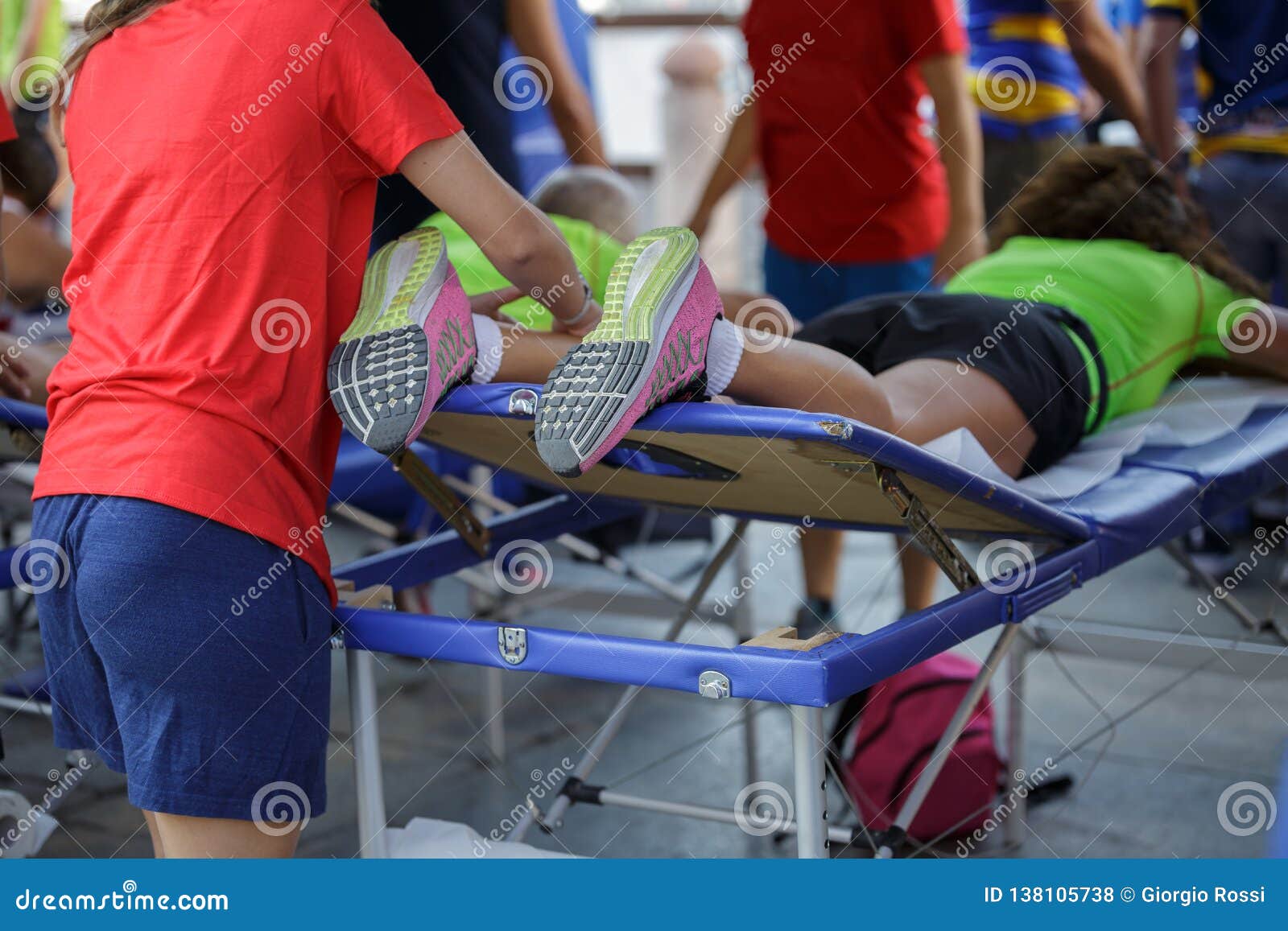 Athlete Lying On A Bed While Having Legs Massaged After A Physical
