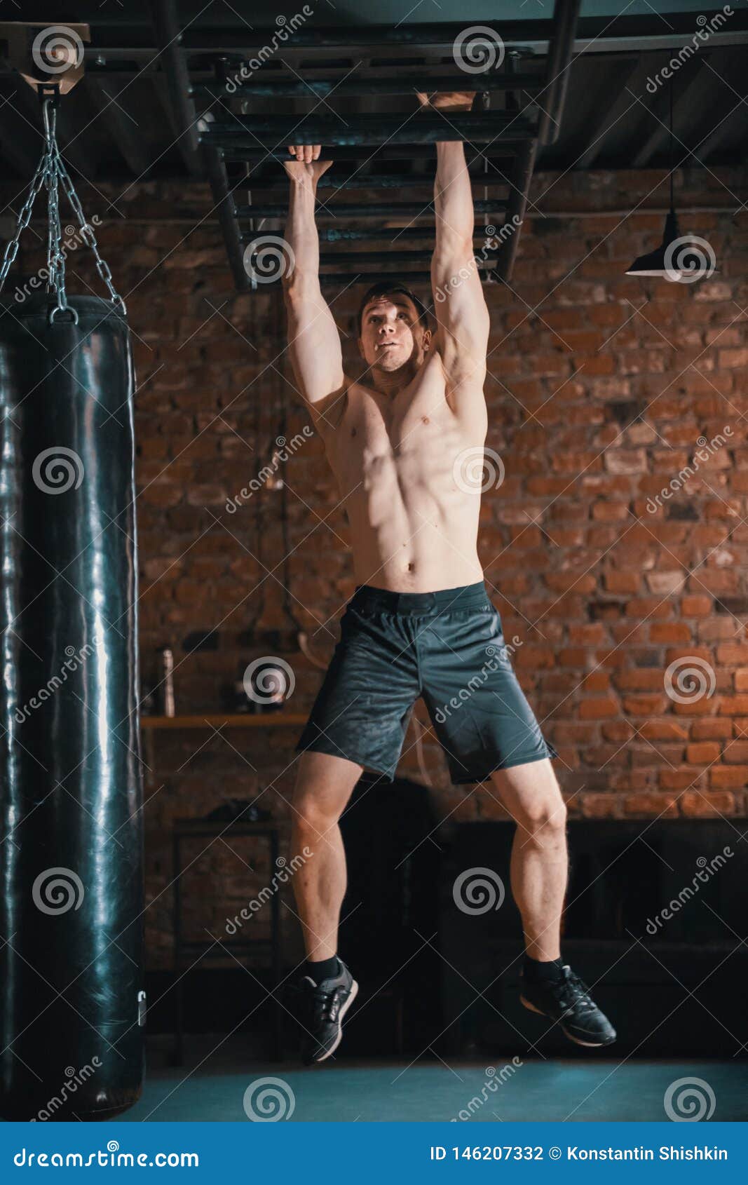 An Athlete Man Moving Forward on His Hands Using a Ceiling Ladder Stock ...