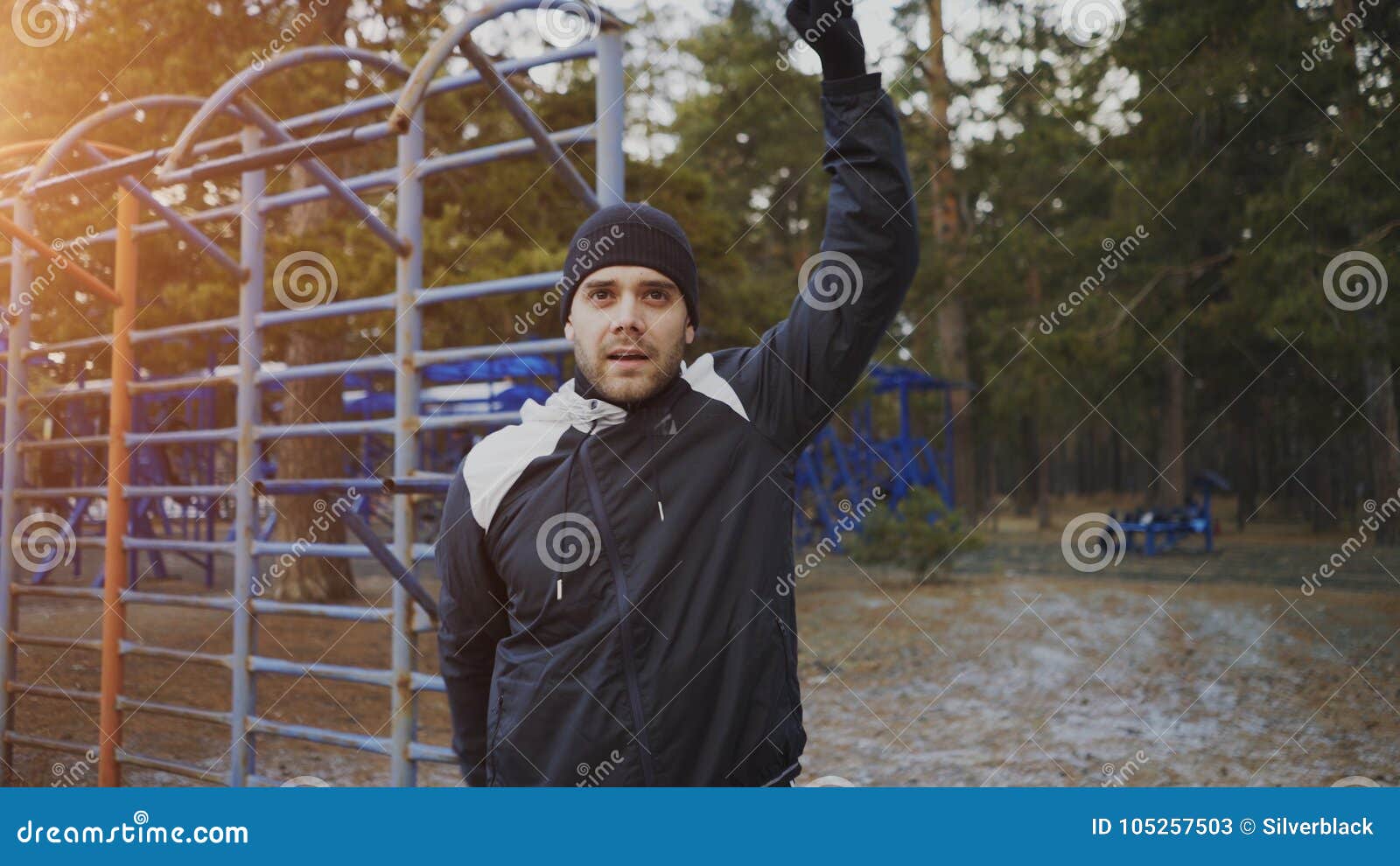 Young Athlete Man Warming Up Before Workout Training In Winter Park