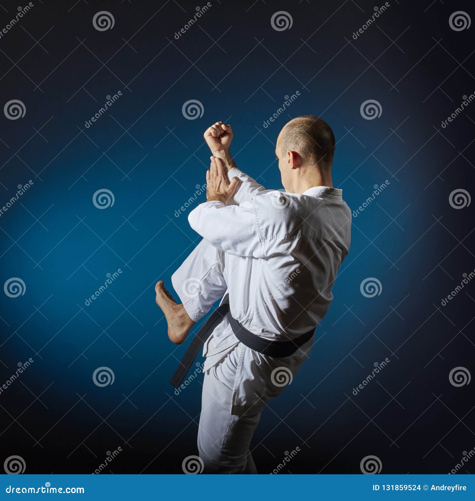 Athlete Performs Formal Karate Exercises on Blue Background with ...