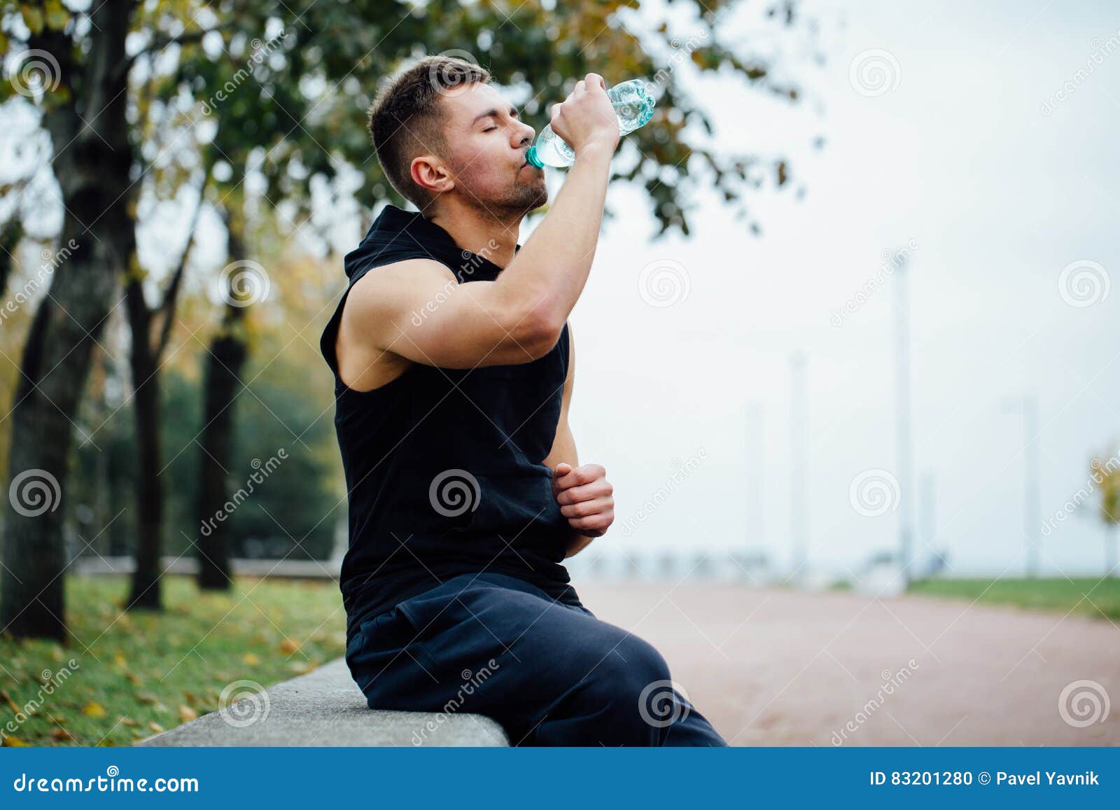 Athlete Resting on Bench in Park after Running with Bottle of Water ...