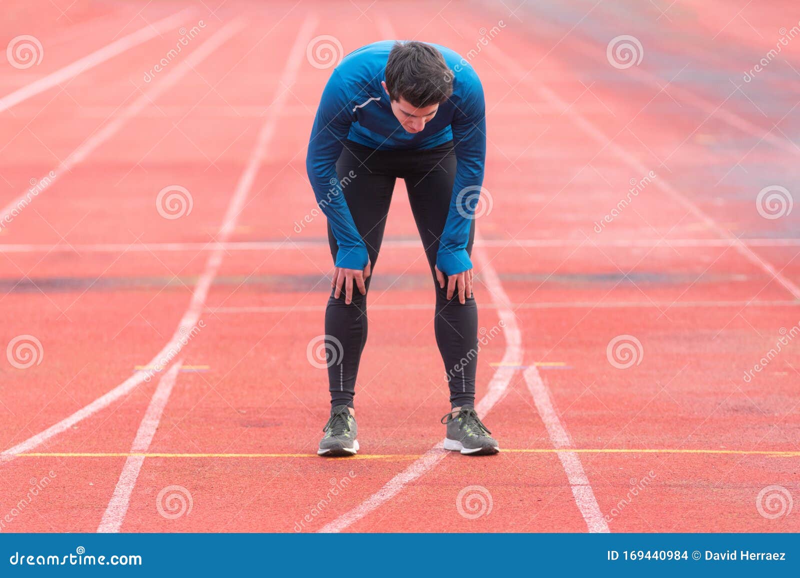 Athlete Young Man Tired, Resting on Running Track. Stock Photo - Image ...