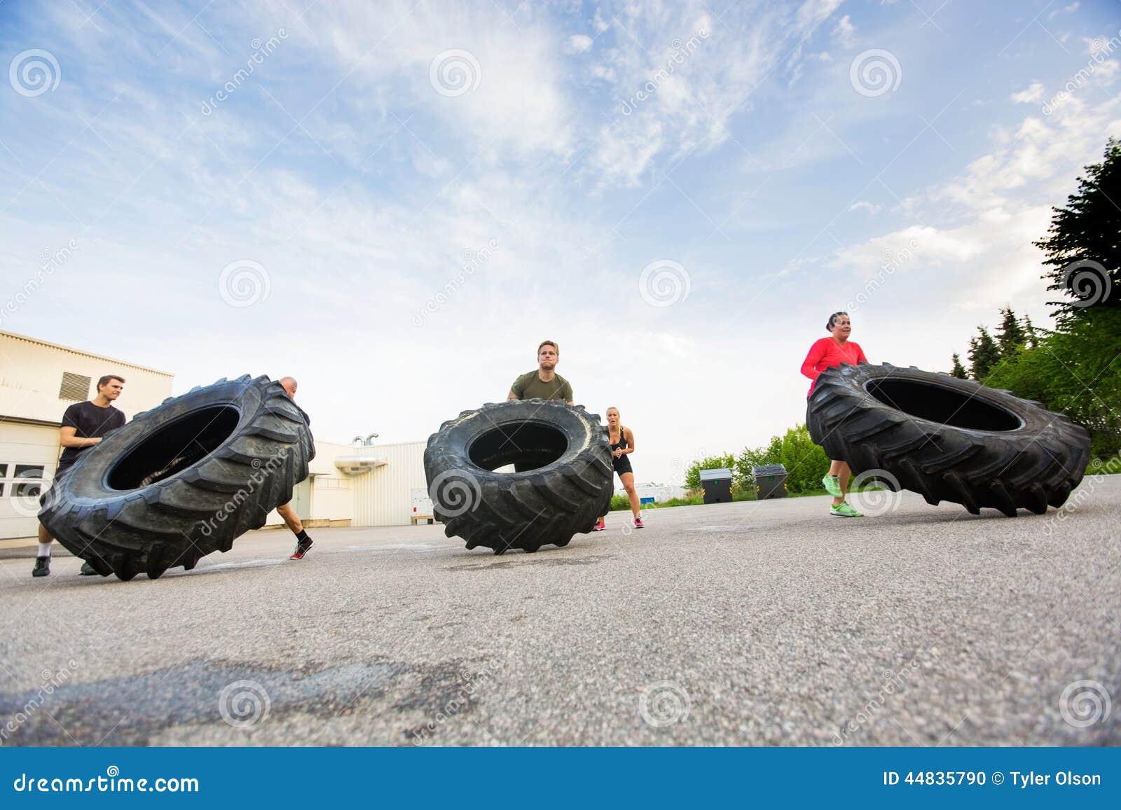Athletes Doing Tire-Flip Exercise Stock Photo - Image of concentration ...