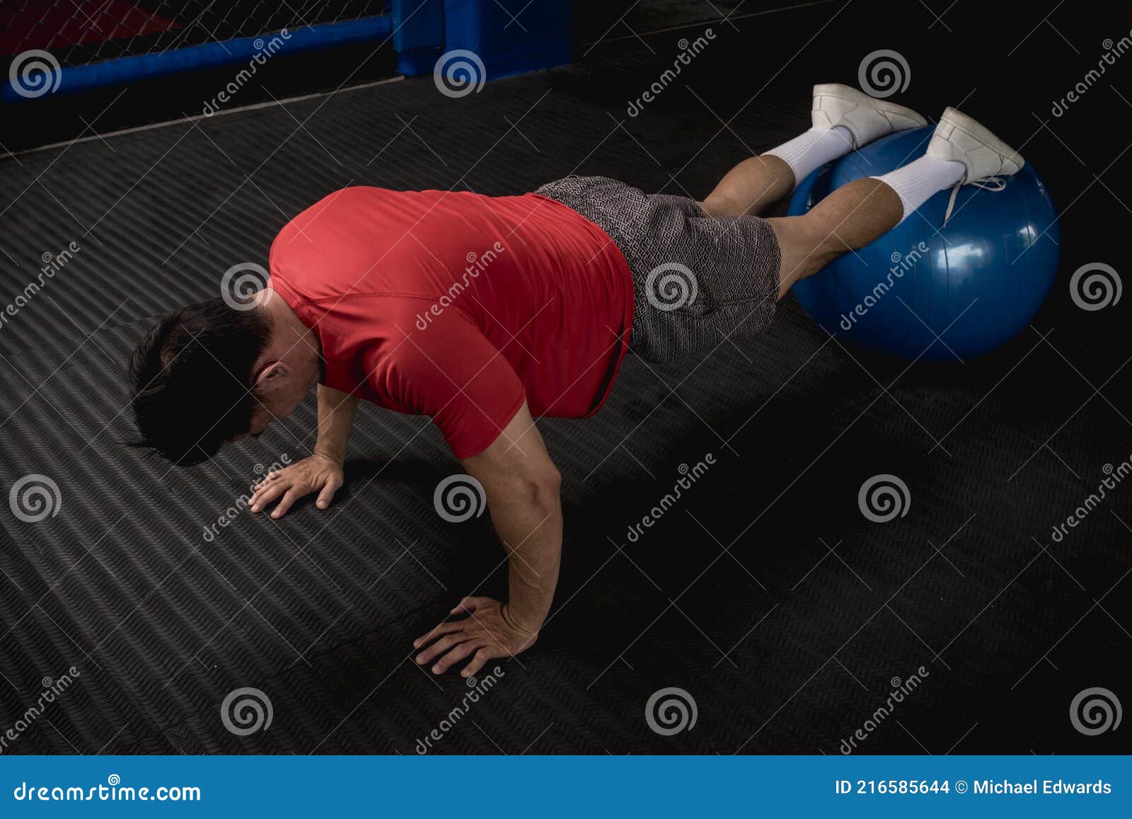 An Athletic and Fit Asian Man Does Pushups on a Stability Ball ...