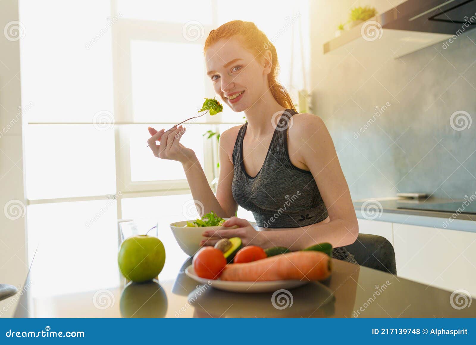Athletic Girl with Gym Clothes Eats Salad in the Kitchen Stock Photo ...
