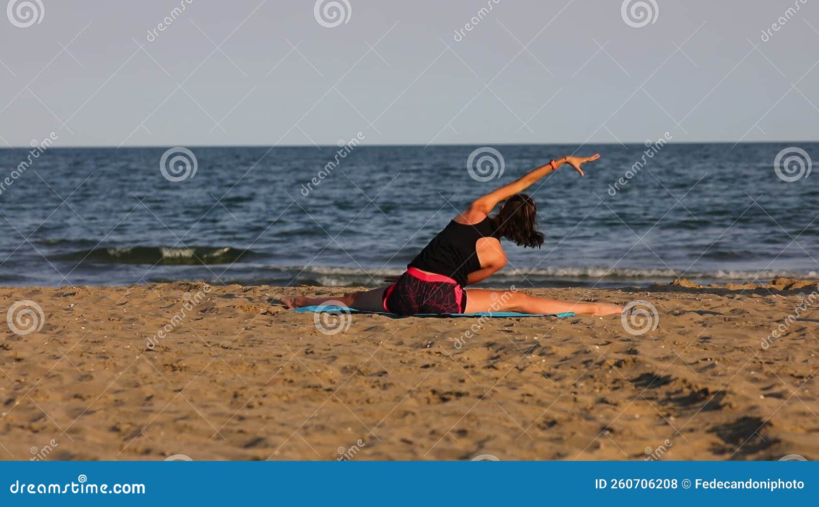 Athletic Girl Performs Gymnastic Exercises on the Beach by the Sea ...