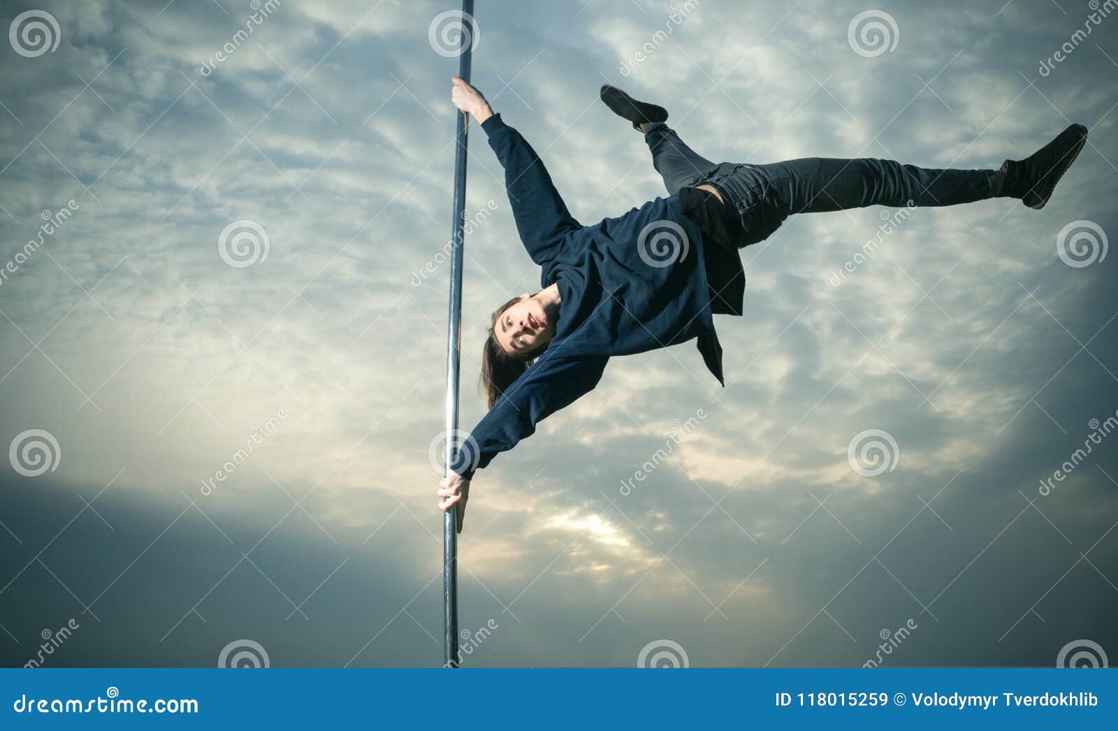 Athletic Guy Make Acrobatic Elements on Pylon. Athletic Man Train on ...