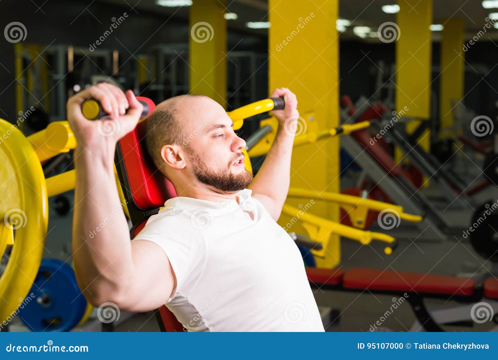Athletic Male Doing Workouts with Power Exercise Machine in a Gym Club ...