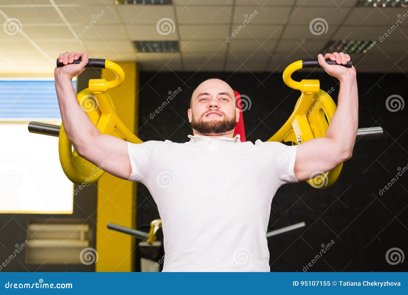 Athletic Male Doing Workouts with Power Exercise Machine in a Gym Club ...