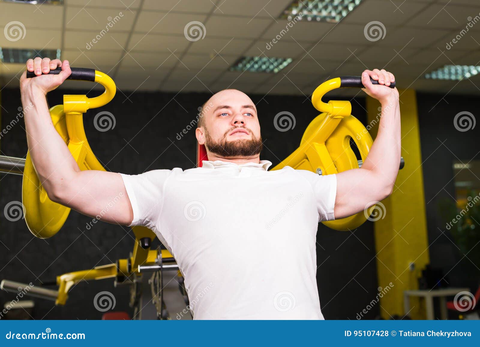Athletic Male Doing Workouts with Power Exercise Machine in a Gym Club ...