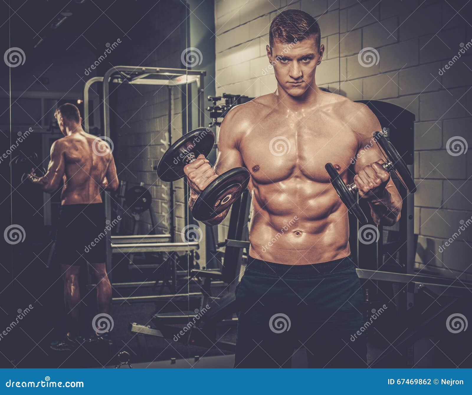 Athletic Man Doing Exercises with Dumbbells in the Gym S Studio Stock ...