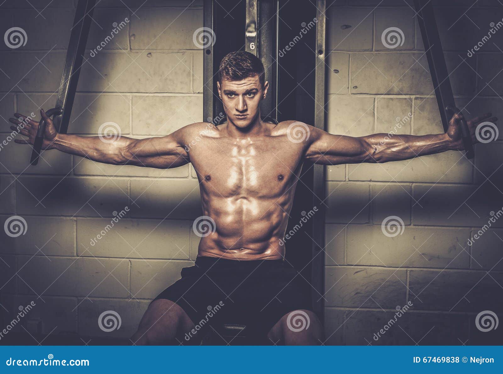 Athletic Man Doing Exercises on Training Apparatus at the Gym S Studio ...