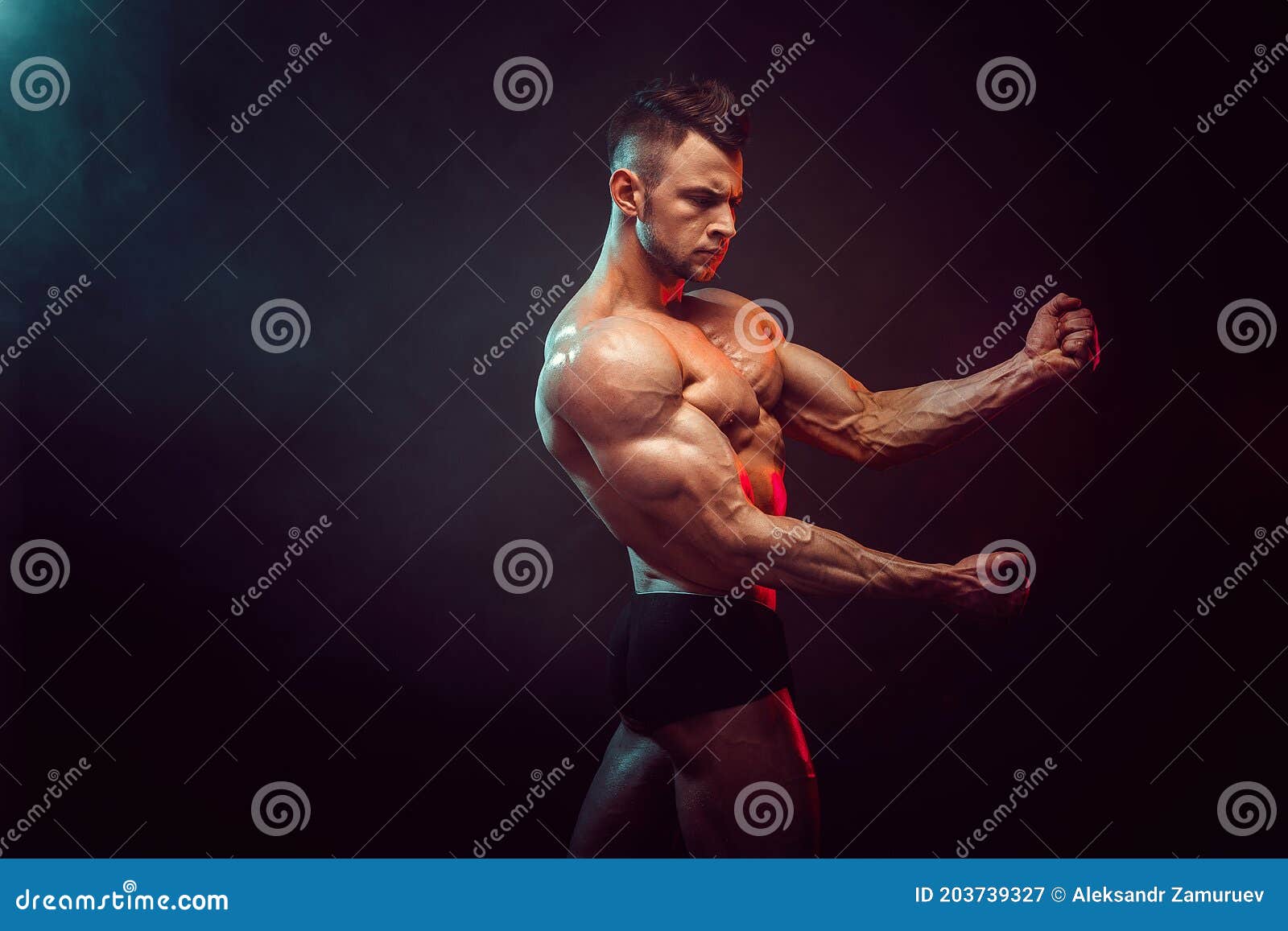 Athletic Man Flexing Muscles in Studio on Dark Background with Smoke ...
