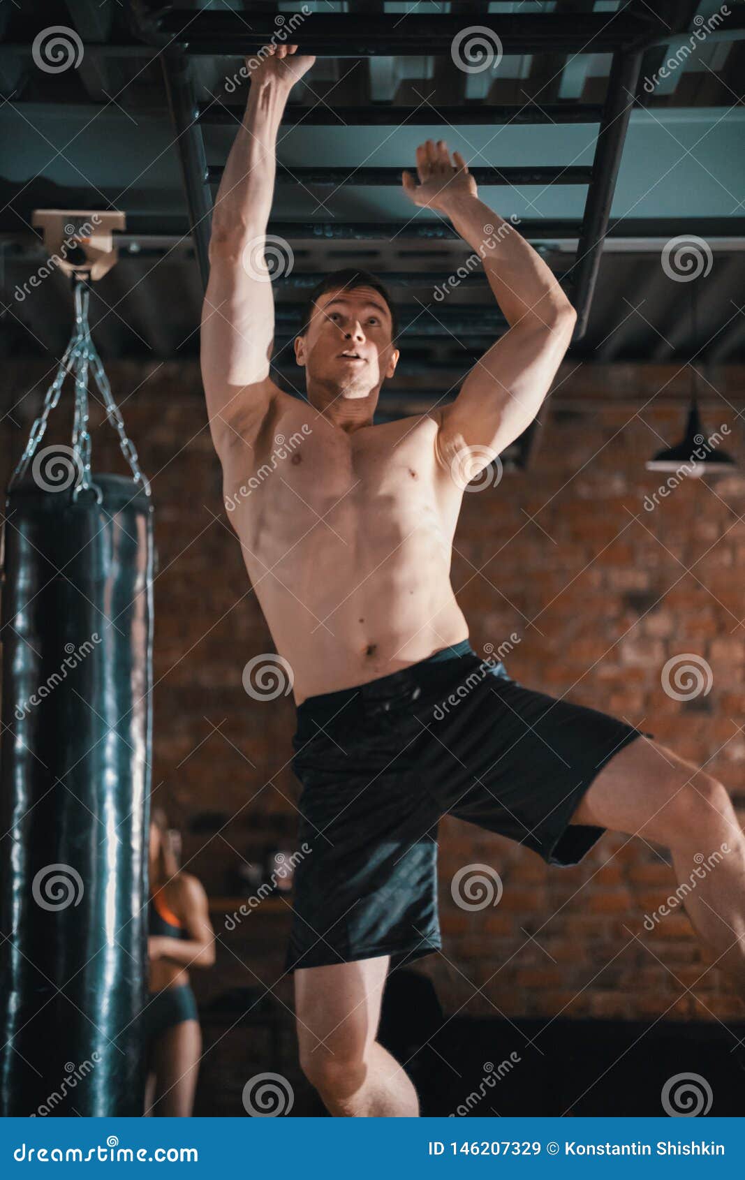 An Athletic Man Moving Forward on His Hands Using a Ceiling Ladder ...