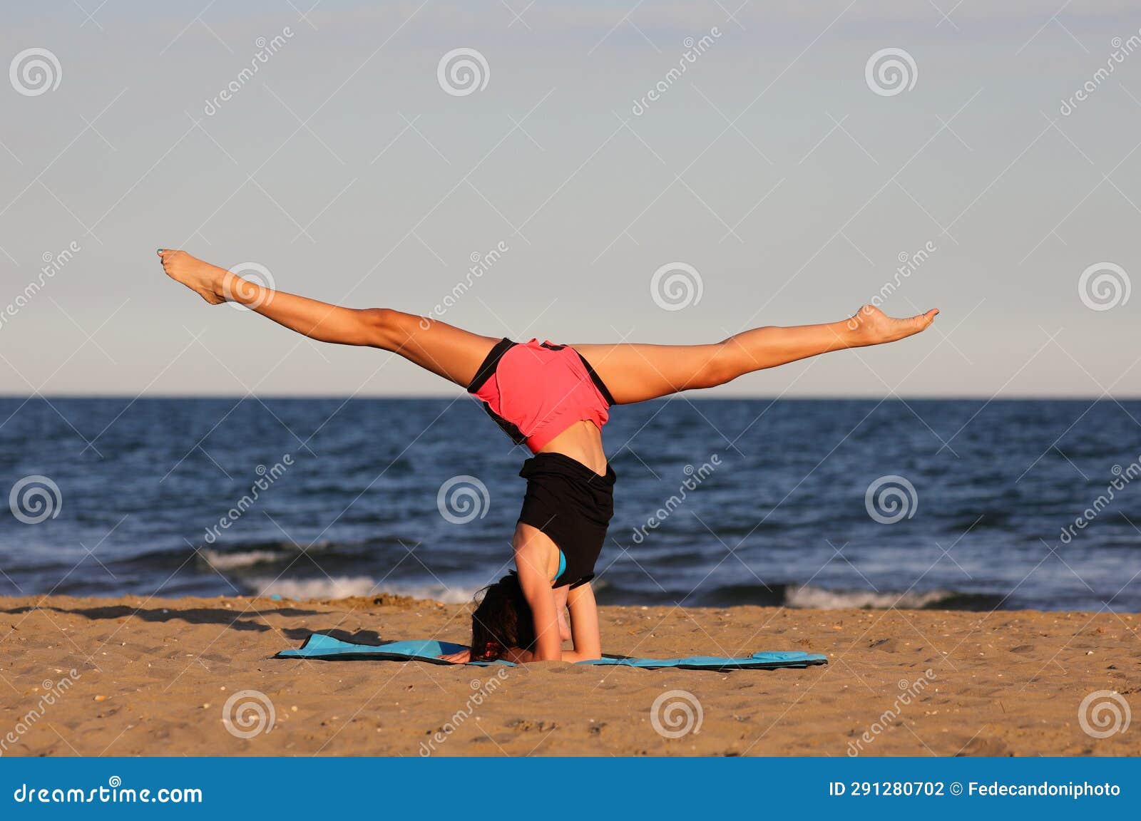 Athletic Slender Girl by the Sea Does Gymnastic Training with Head Down ...