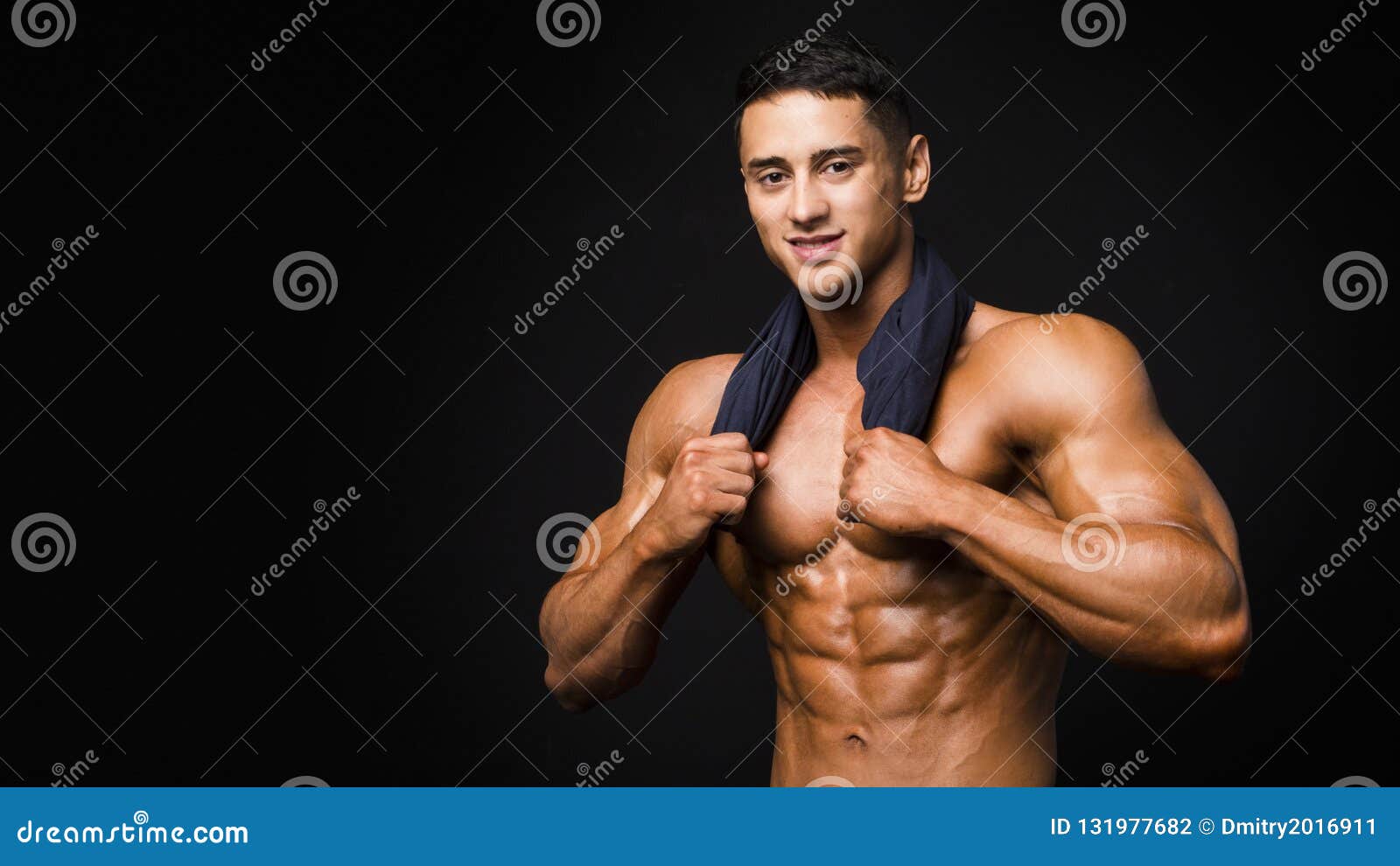 Athletic Strong Smiling Bodybuilder with Towel Over Dark Background ...