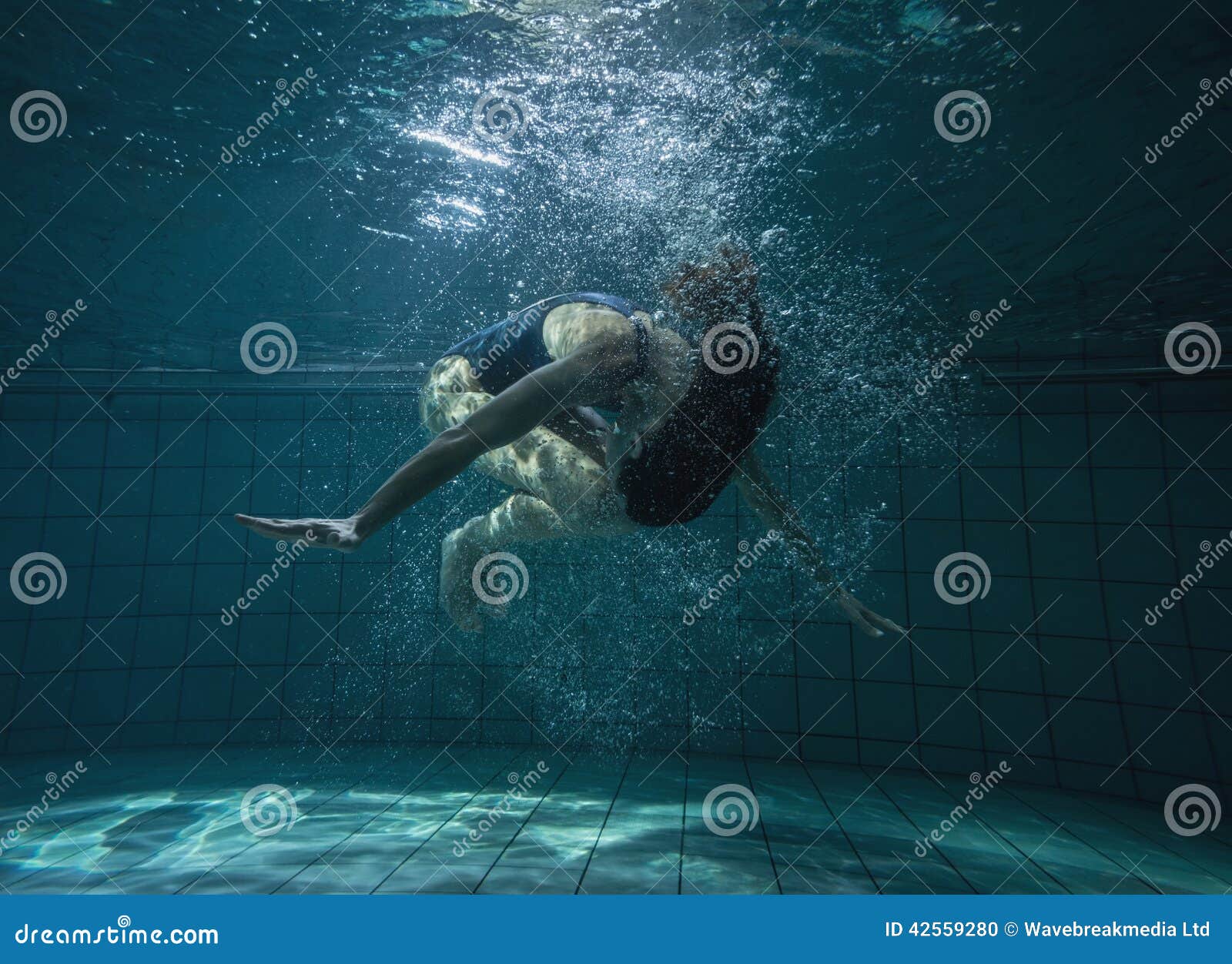 Athletic Swimmer Doing a Somersault Underwater Stock Photo - Image of ...