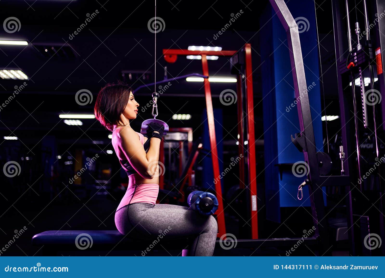 Athletic Woman Doing Exercise for Back, Using Machine, in Gym - Back ...