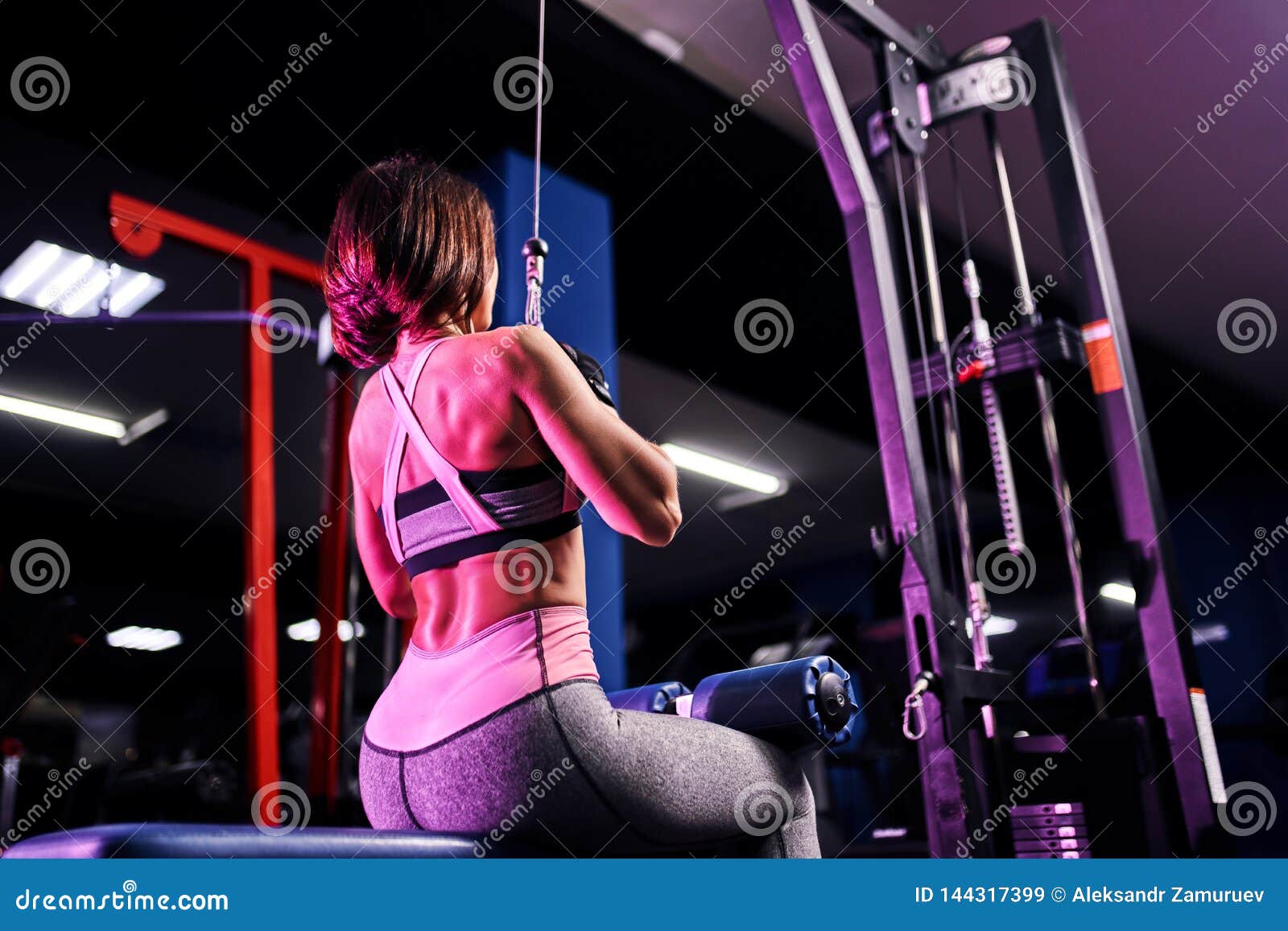 Athletic Woman Doing Exercise for Back, Using Machine, in Gym - Back ...