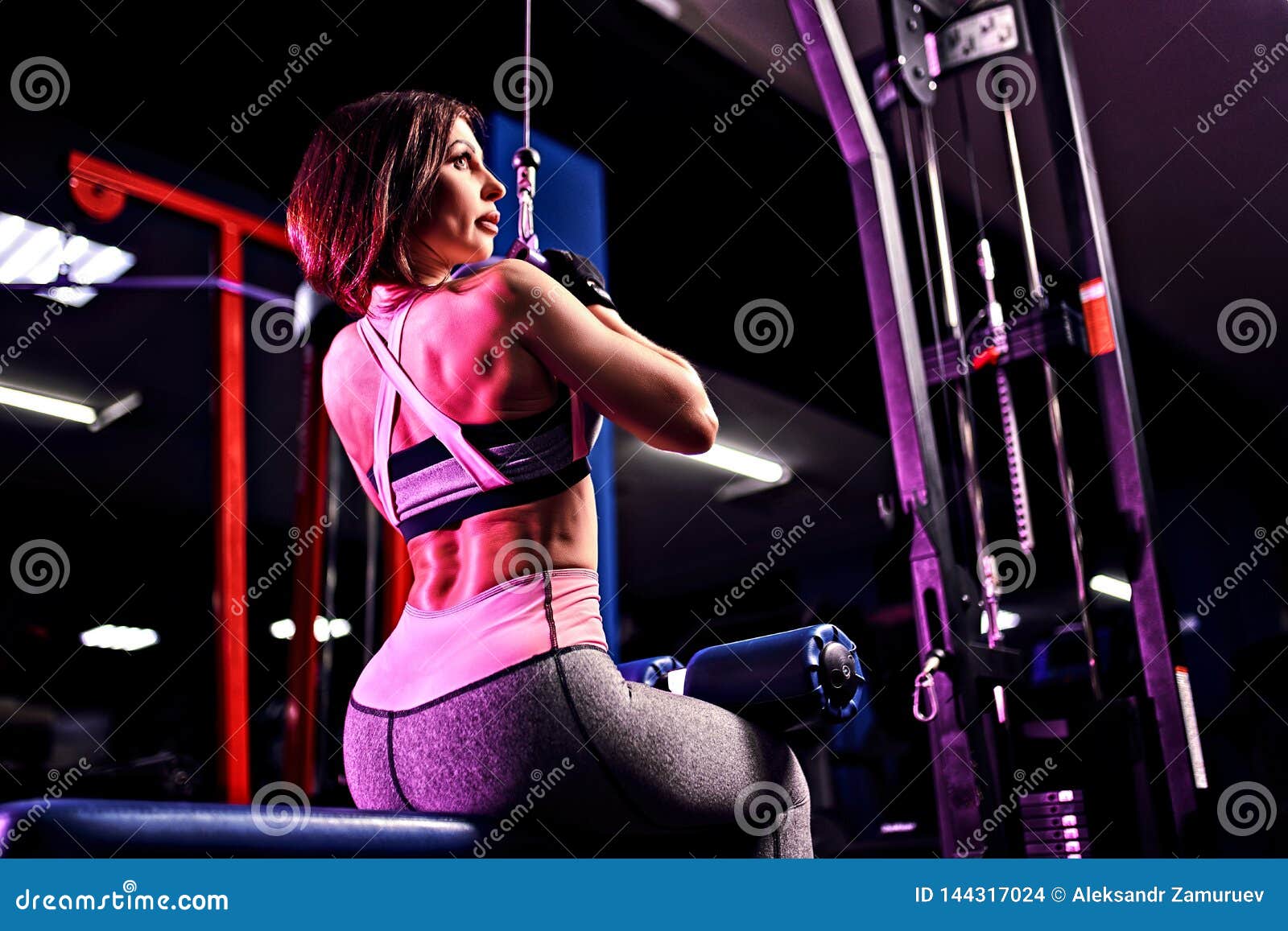 Athletic Woman Doing Exercise for Back, Using Machine, in Gym - Back ...
