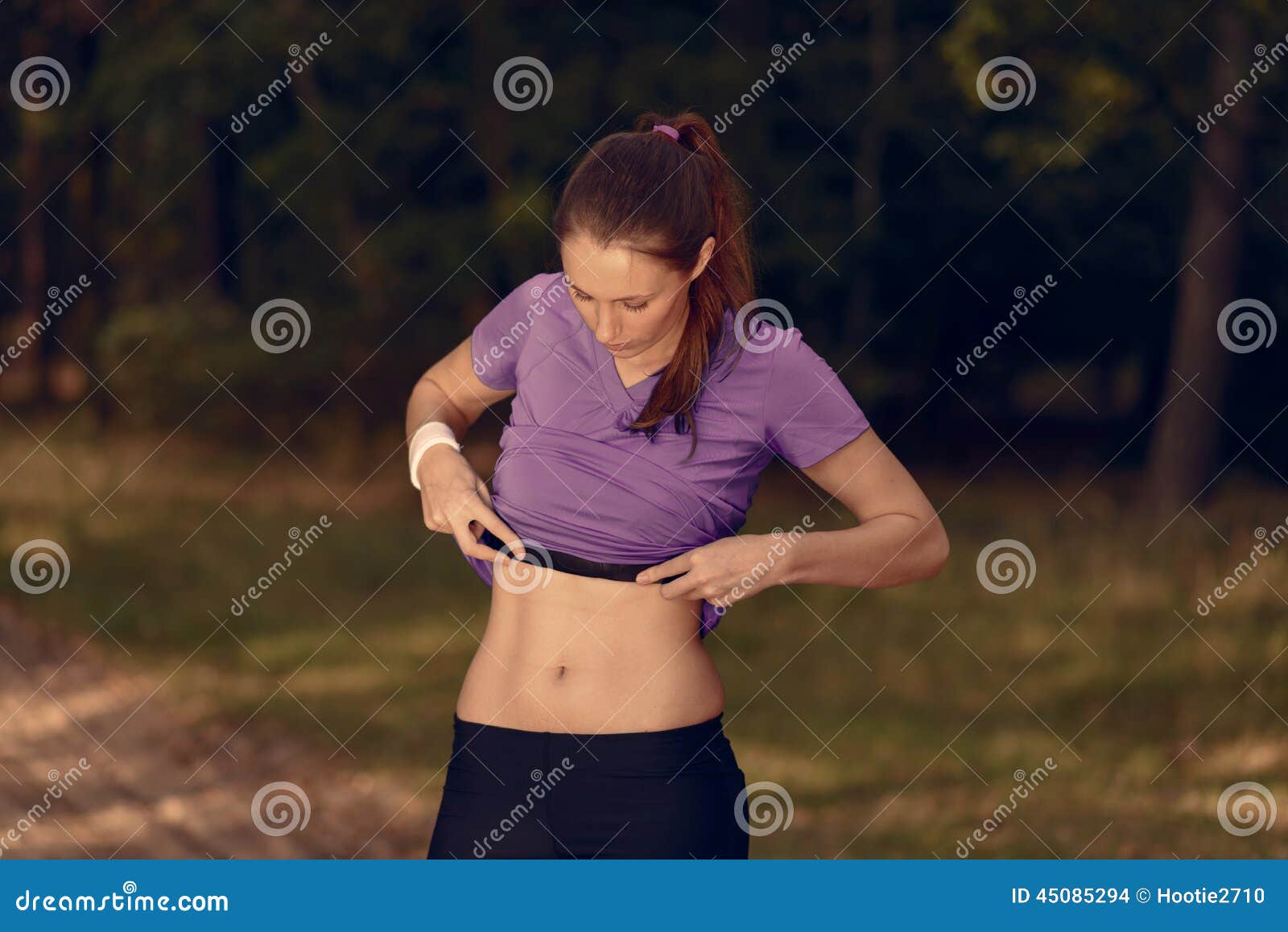 Atleta De La Mujer Que Comprueba Su Correa Del Pulso Foto de archivo ...