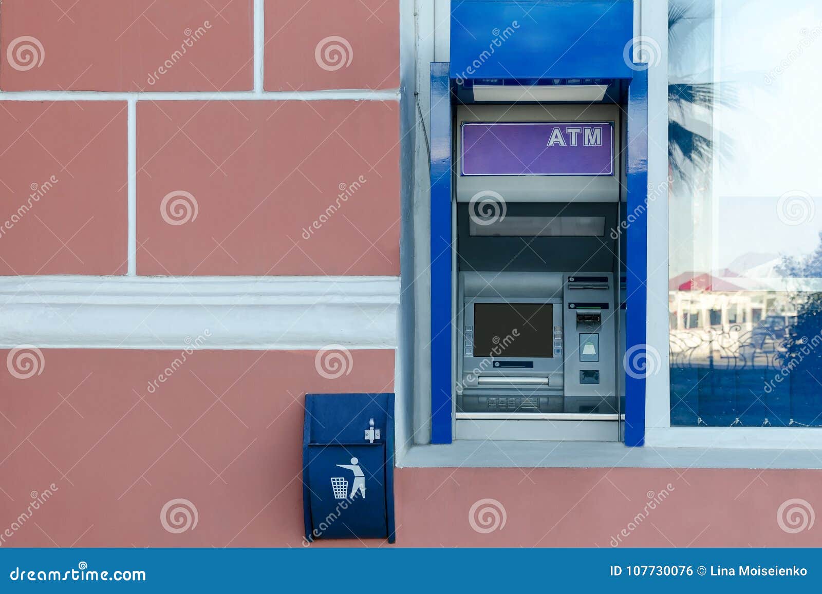 ATM in the Wall of the Building Near the Window, Near it a Small Trash ...