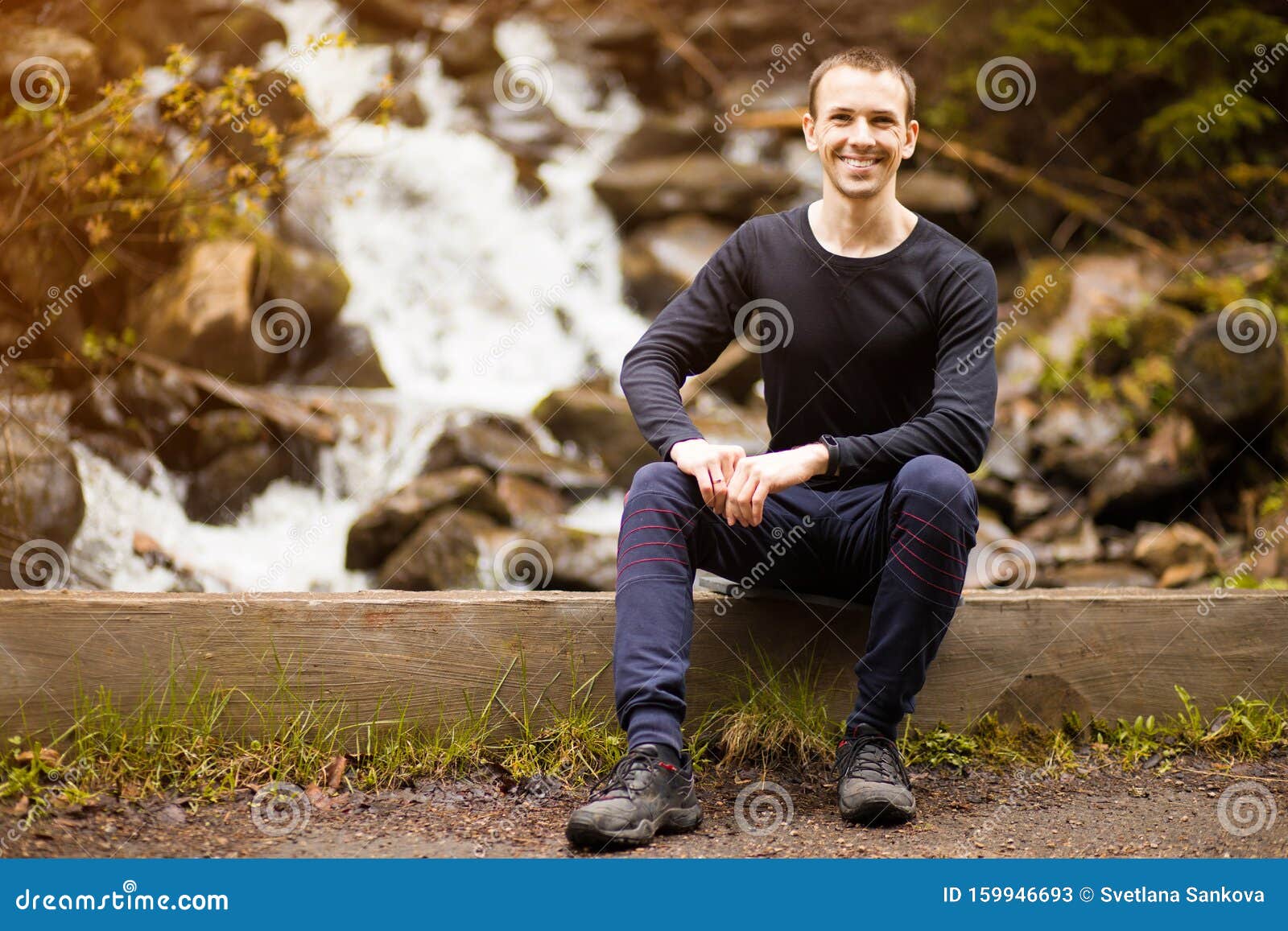 Atractivo Joven Sentado En Una Cascada Forestal Imagen de archivo ...