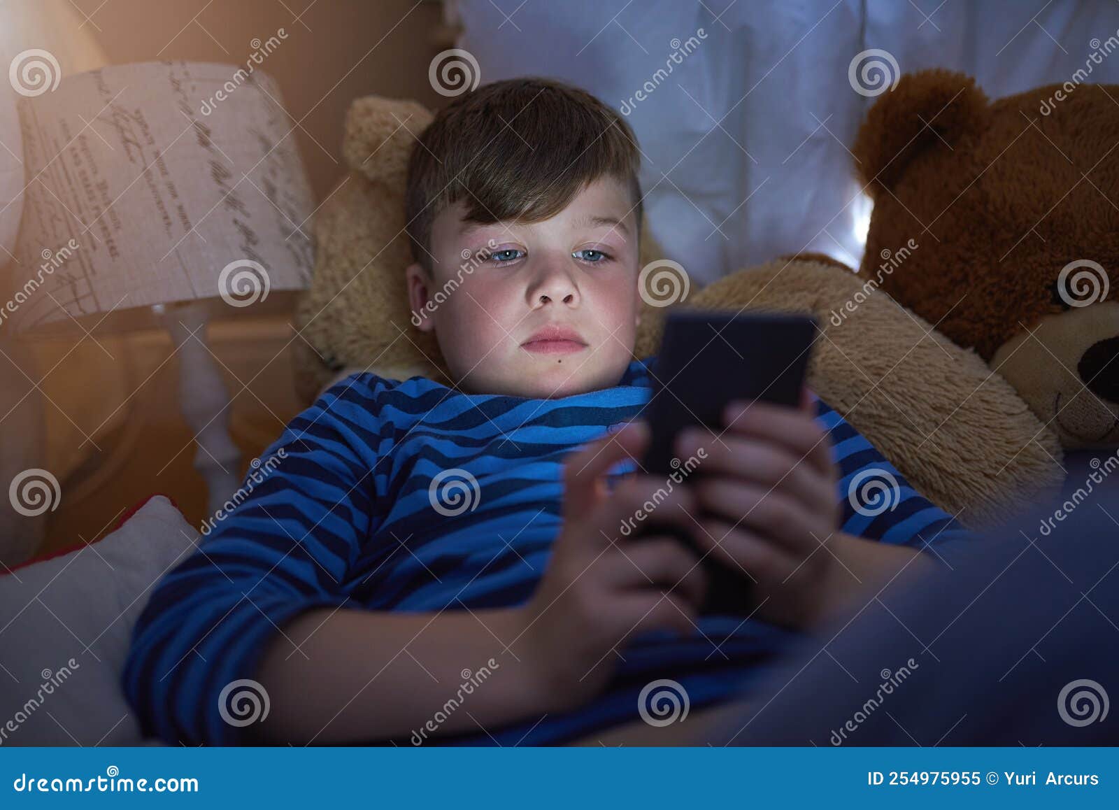 Attached To Technology. a Young Boy Using a Cellphone at Night in Bed ...