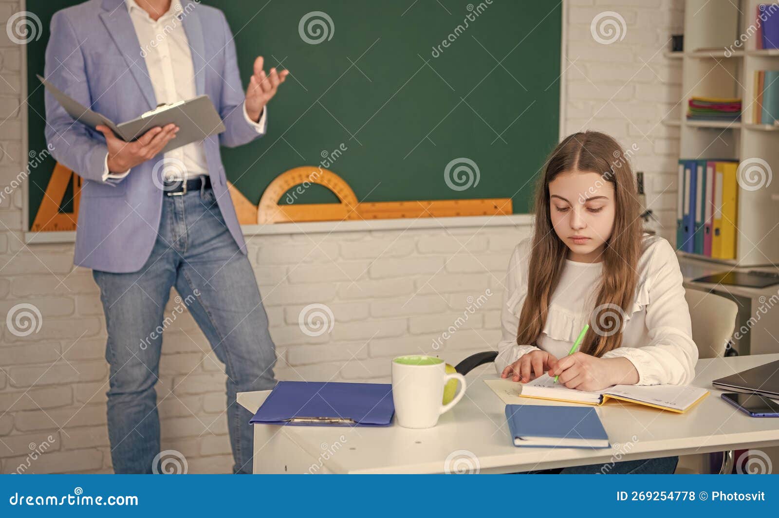 Attentive Child Study in Classroom with Teacher. Selective Focus Stock ...