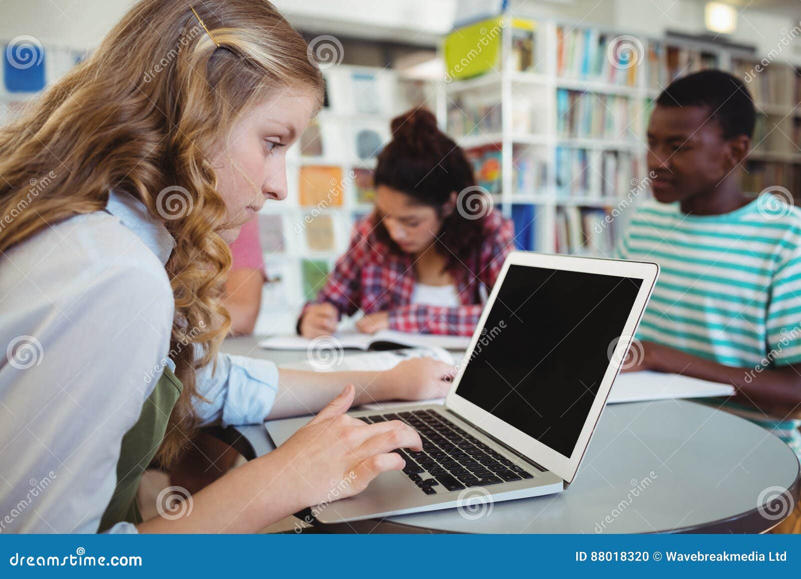 Attentive Schoolgirl Using Laptop with Her Classmates in Studying ...